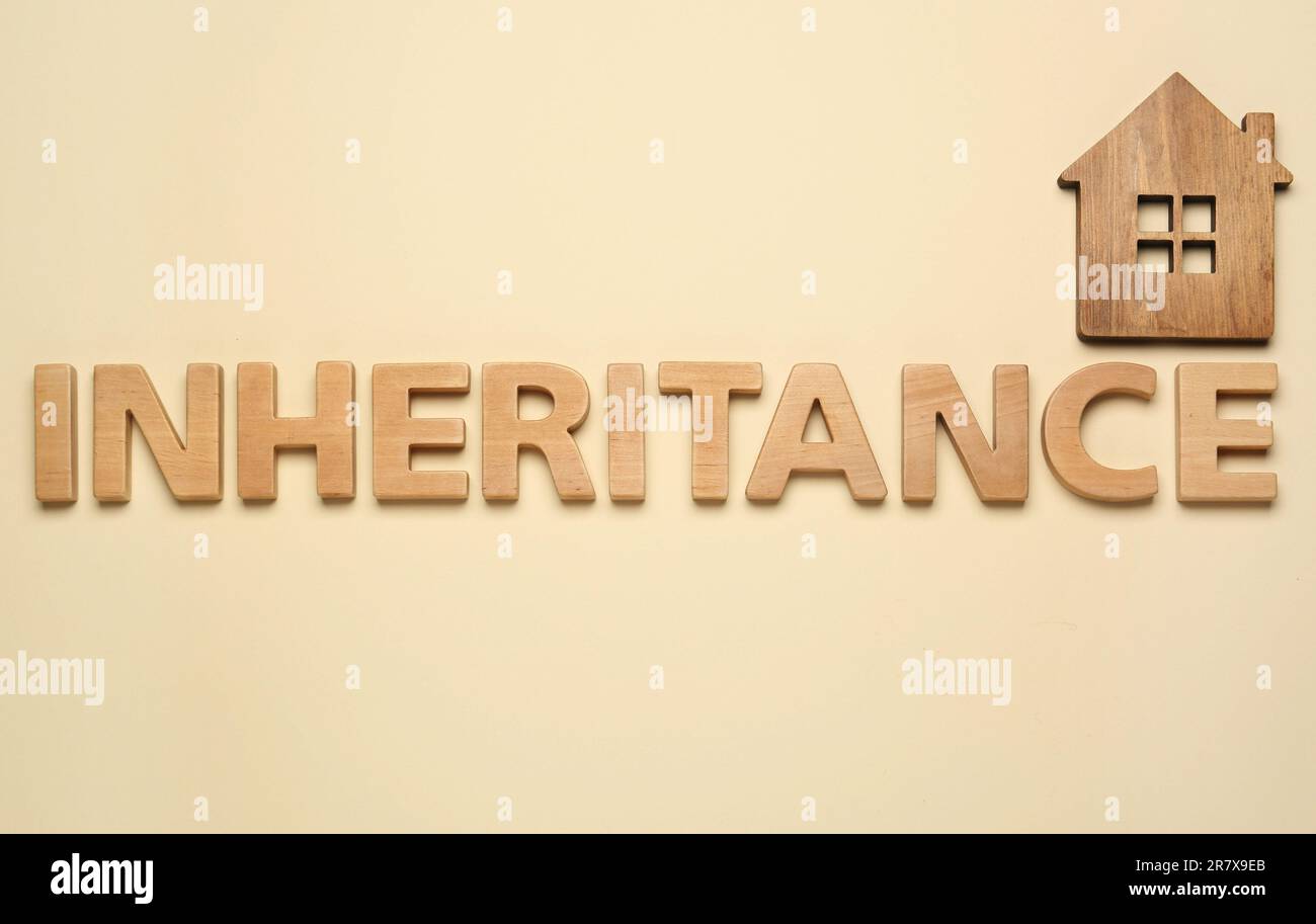 Word Inheritance made with wooden letters and house model on beige ...