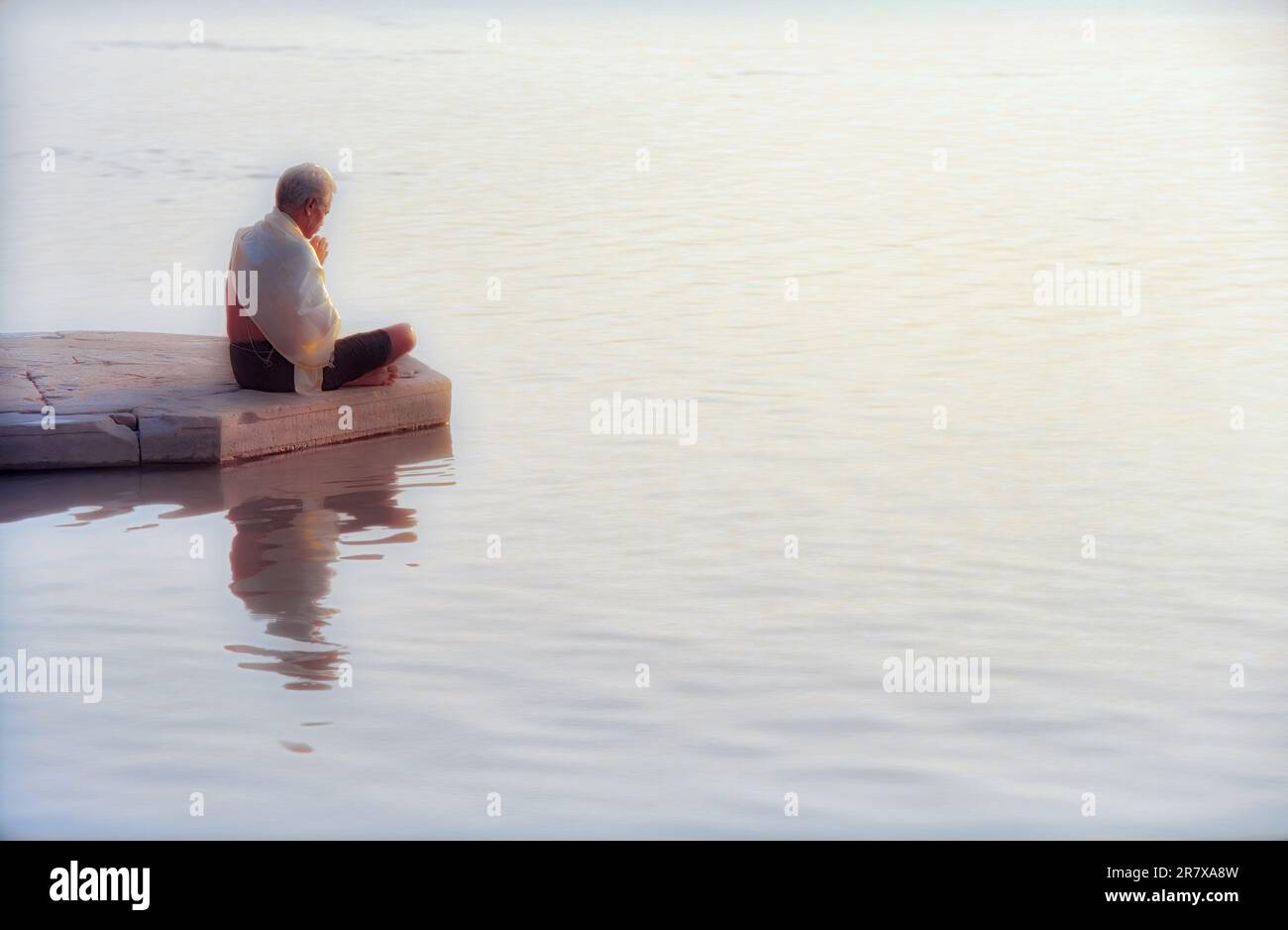 Man praying or meditating at the edge of the River Ganges, Varanasi ...