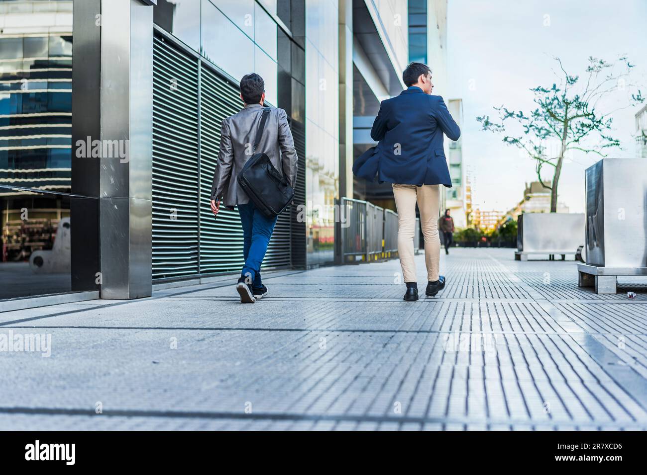 Rear view of two colleagues going to a meeting while they are walking ...
