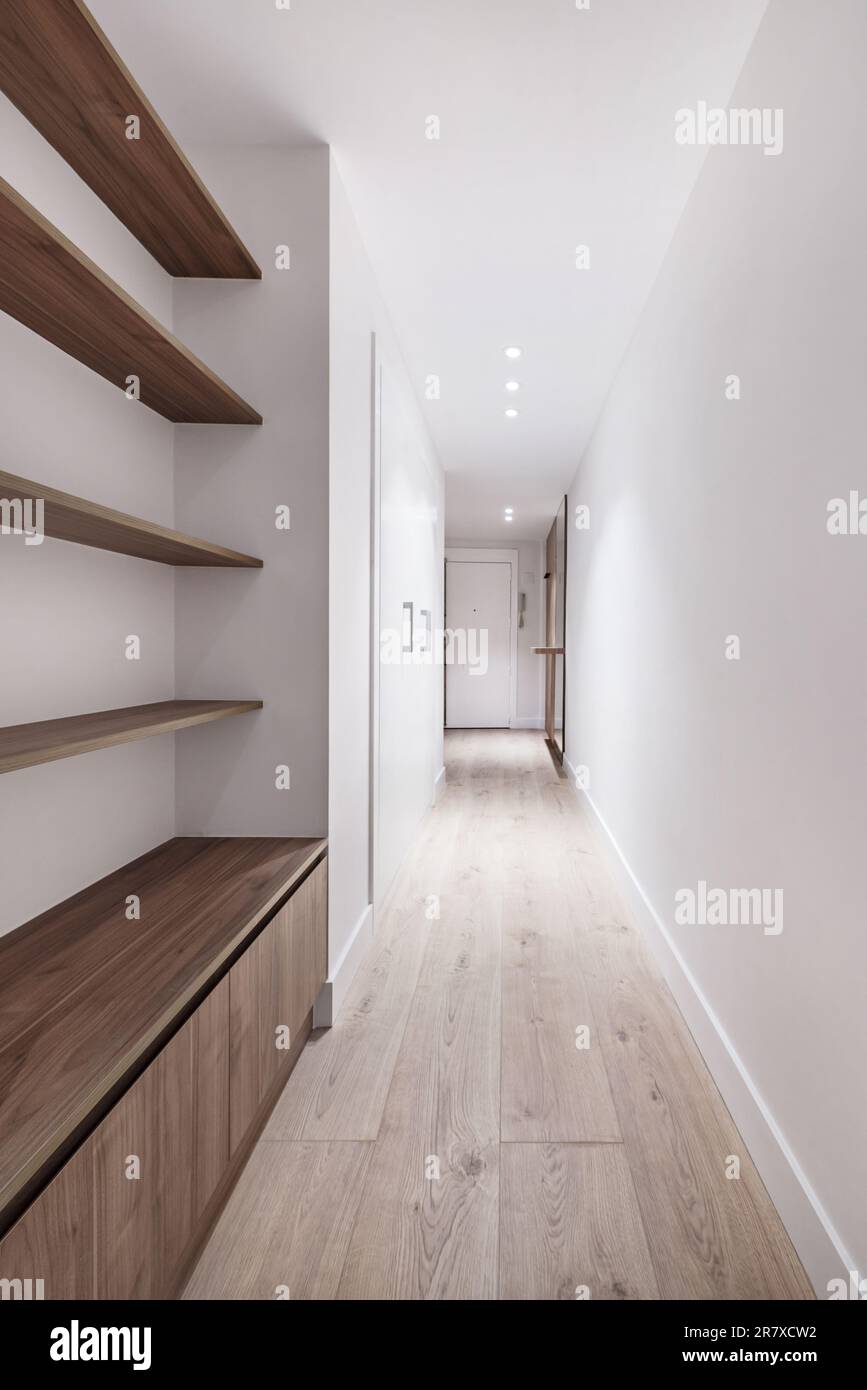 the hallway of a house with cabinets and wooden shelves is a wall ...