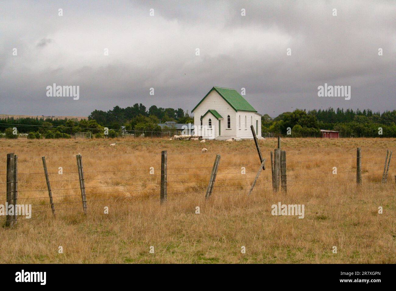 White wooden building with a green roof in a rural farming and vineyard ...