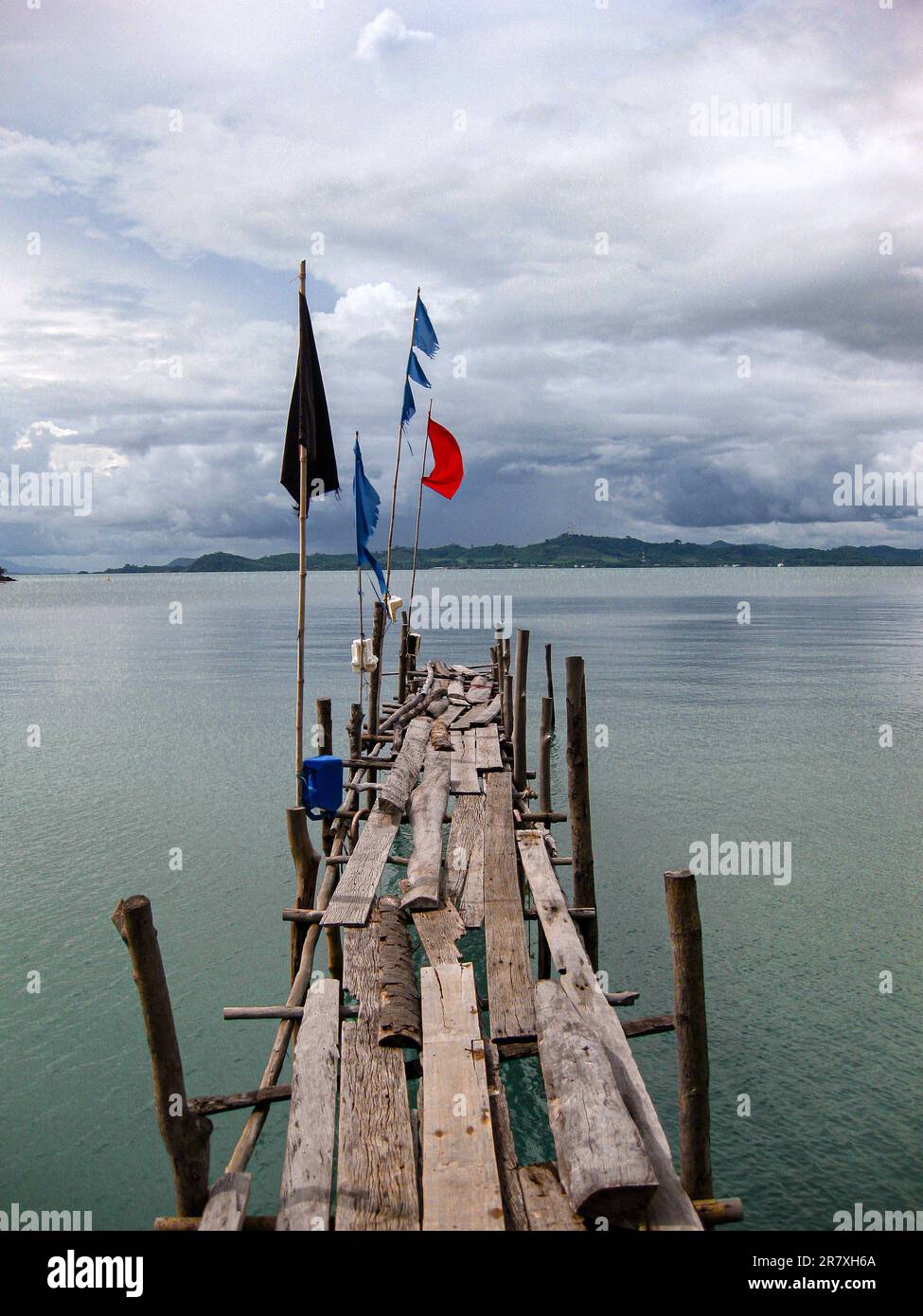 Wooden footbridge lined with flags at a traditional fishing village in ...