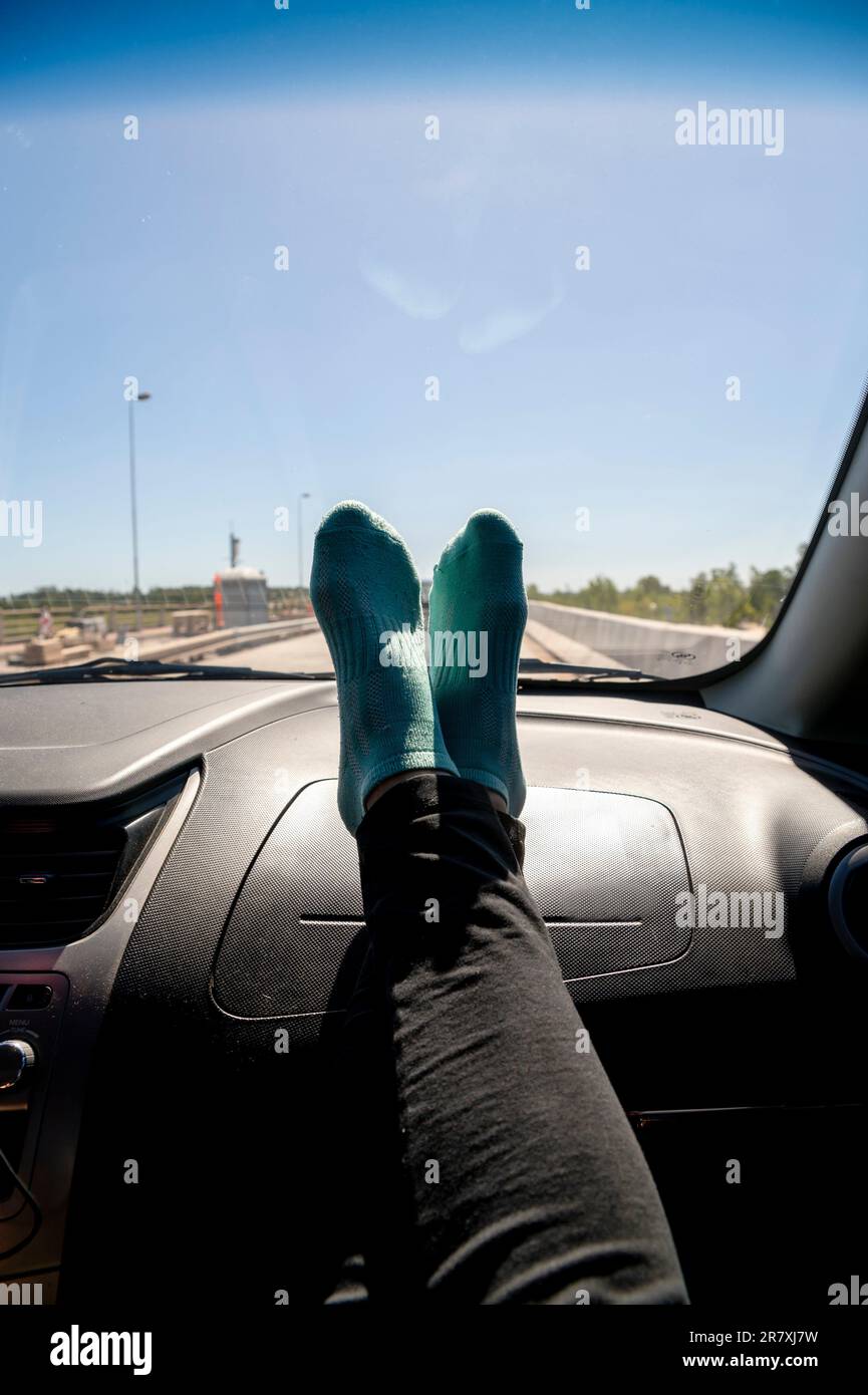 Feet on the dashboard of the car while traveling on route Stock Photo ...