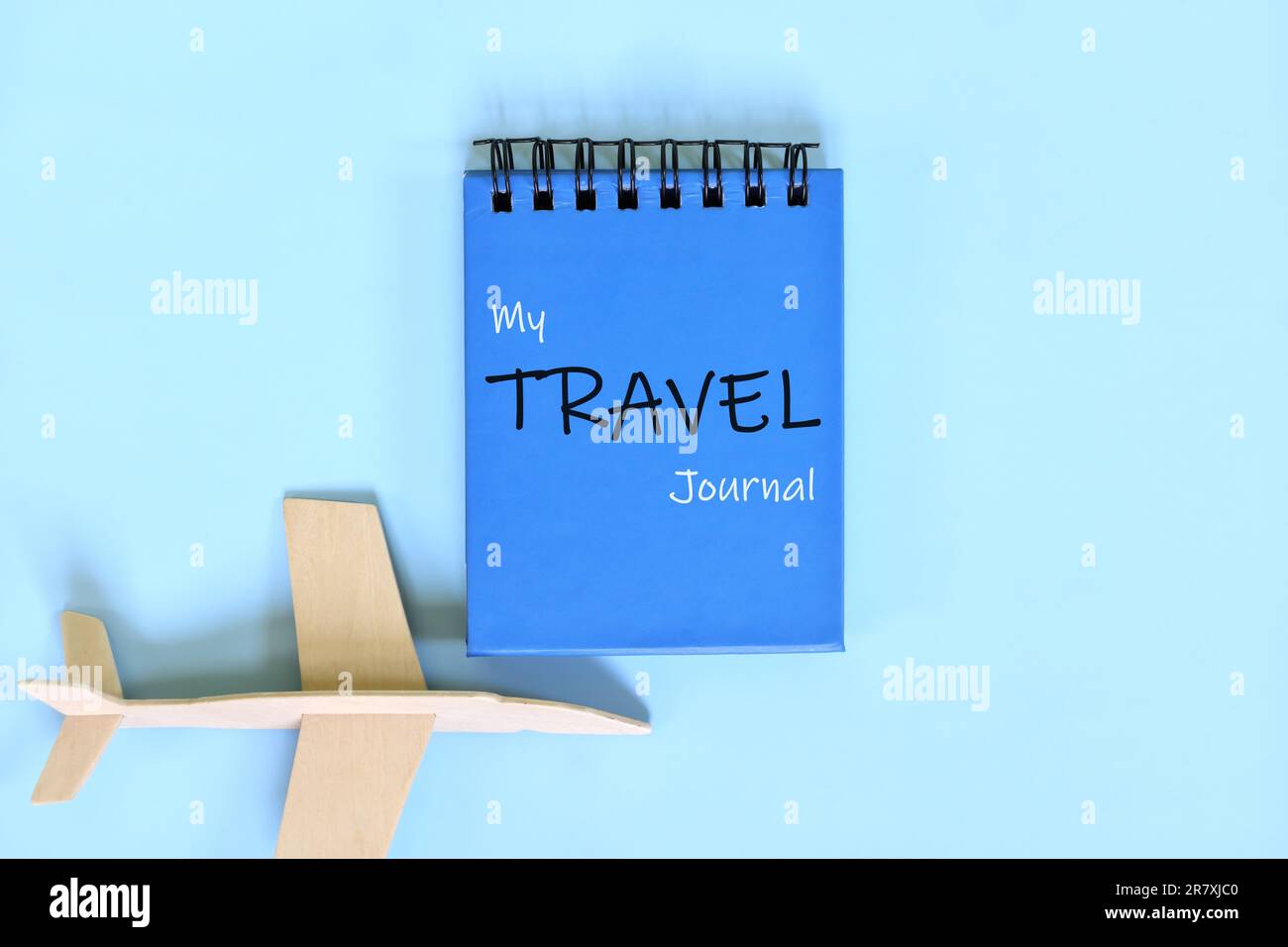 Travel journal flat lay composition with wooden airplane and boarding ...