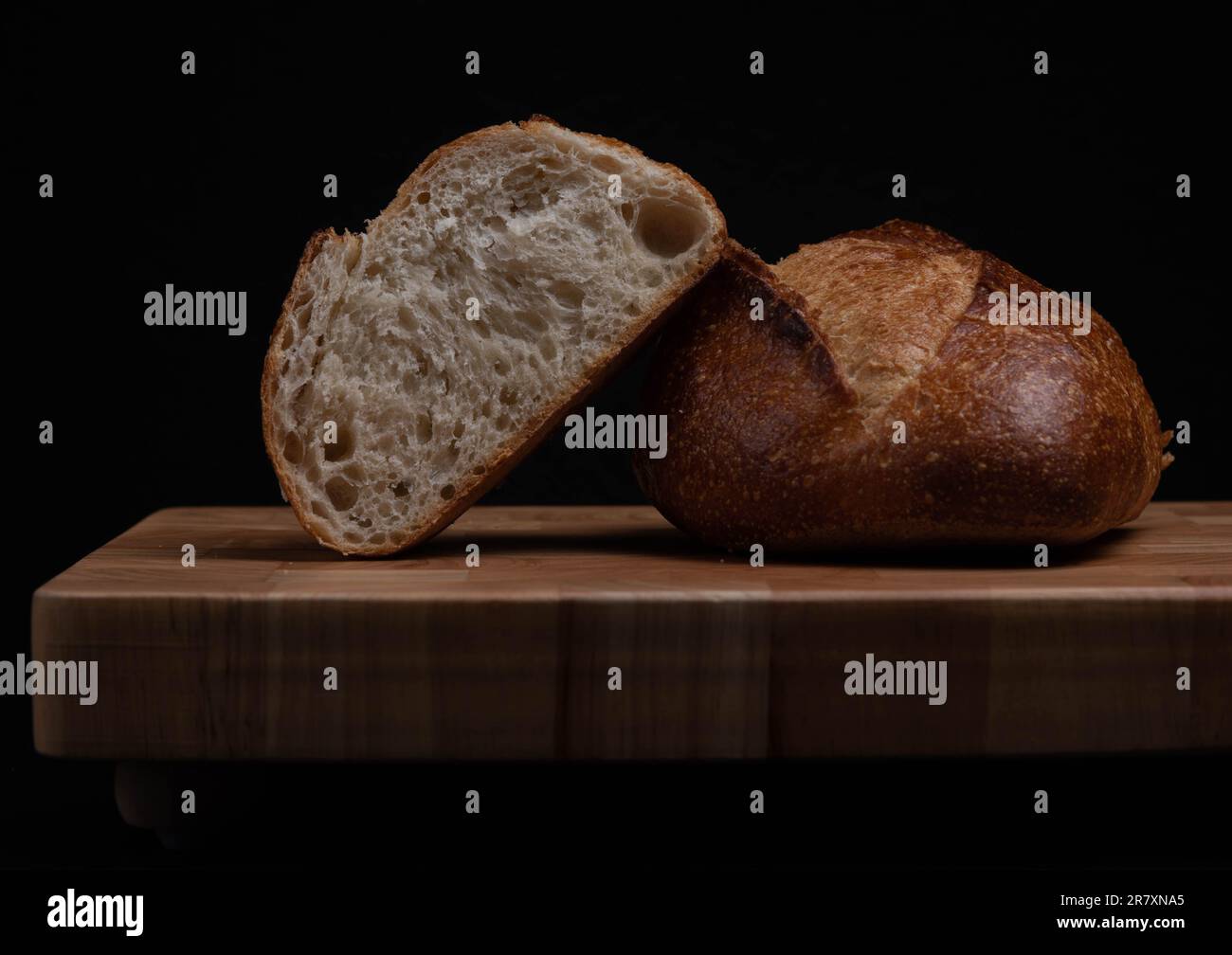 Homemade sourdough crusty loaves of bread on wooden background. Still ...
