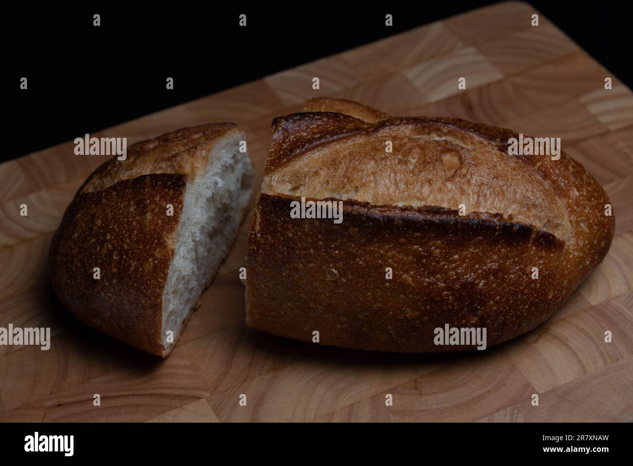 Homemade sourdough crusty loaves of bread on wooden background. Still ...