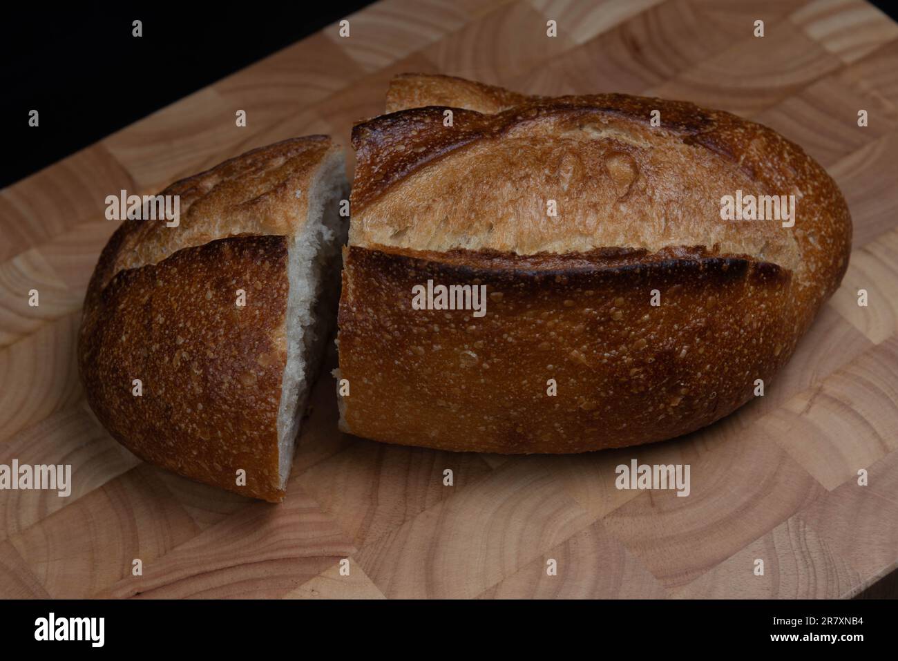 Homemade sourdough crusty loaves of bread on wooden background. Still ...