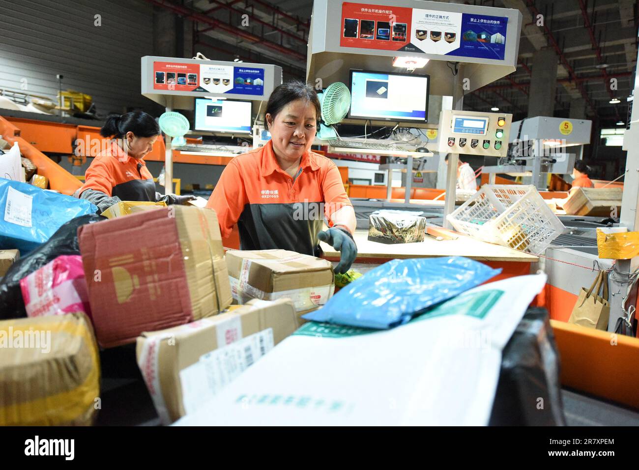 Express workers sort parcels on an assembly line at an e-commerce ...