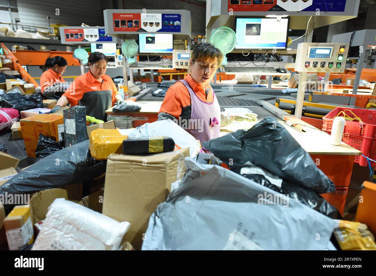 Express workers sort parcels on an assembly line at an e-commerce ...