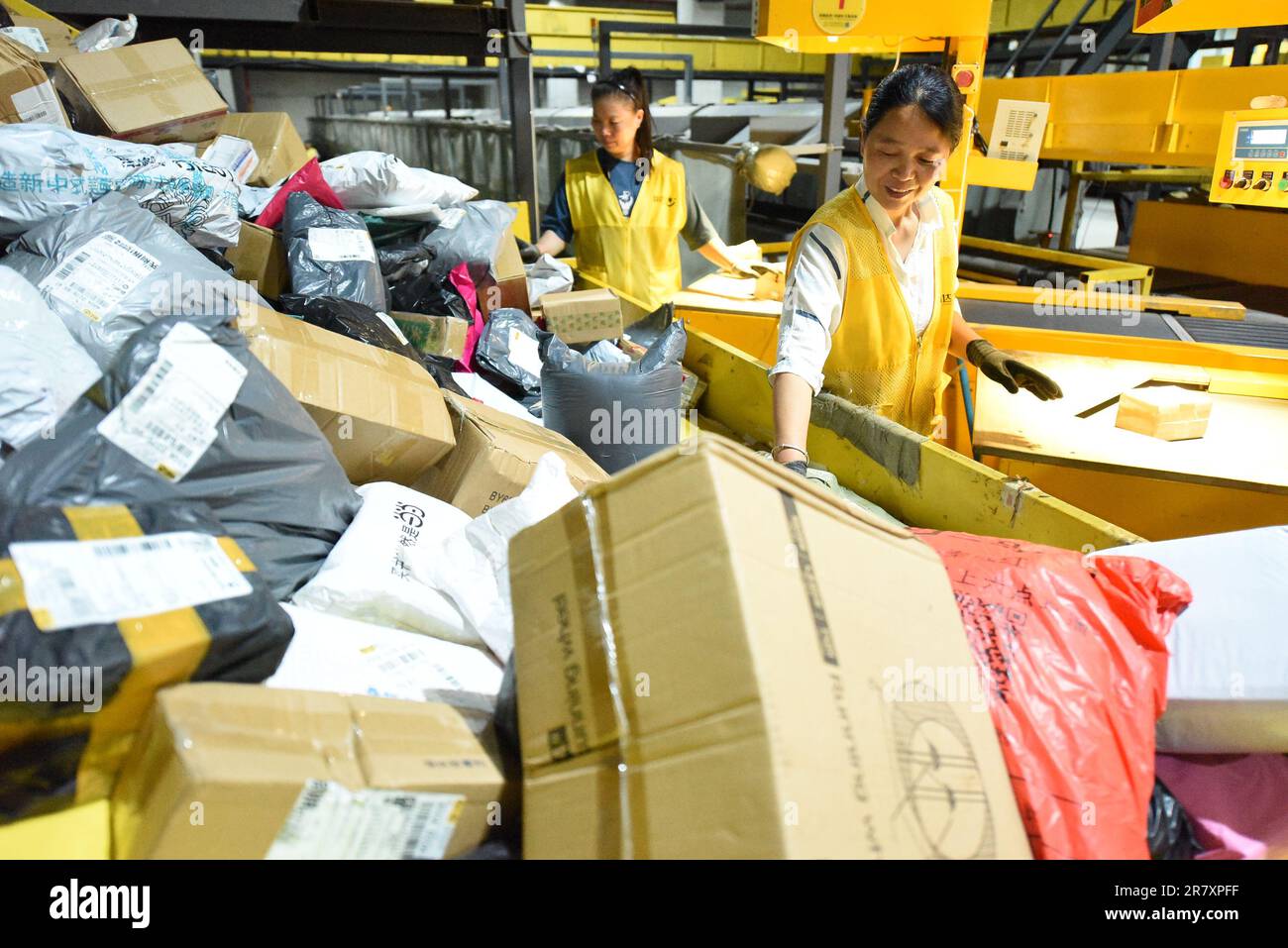 Express workers sort parcels on an assembly line at an e-commerce ...