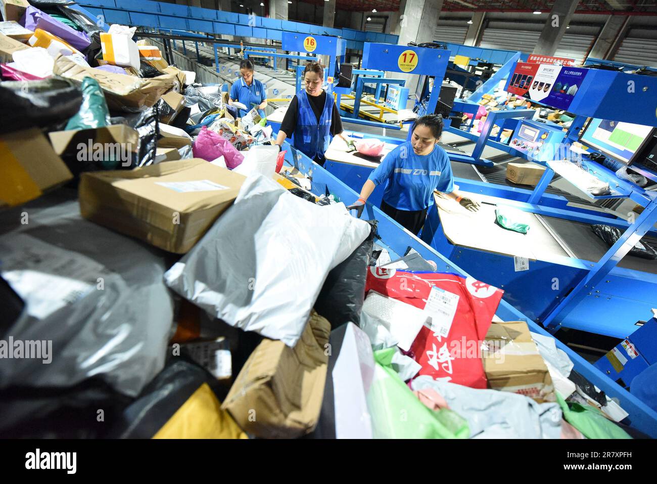 Express workers sort parcels on an assembly line at an e-commerce ...