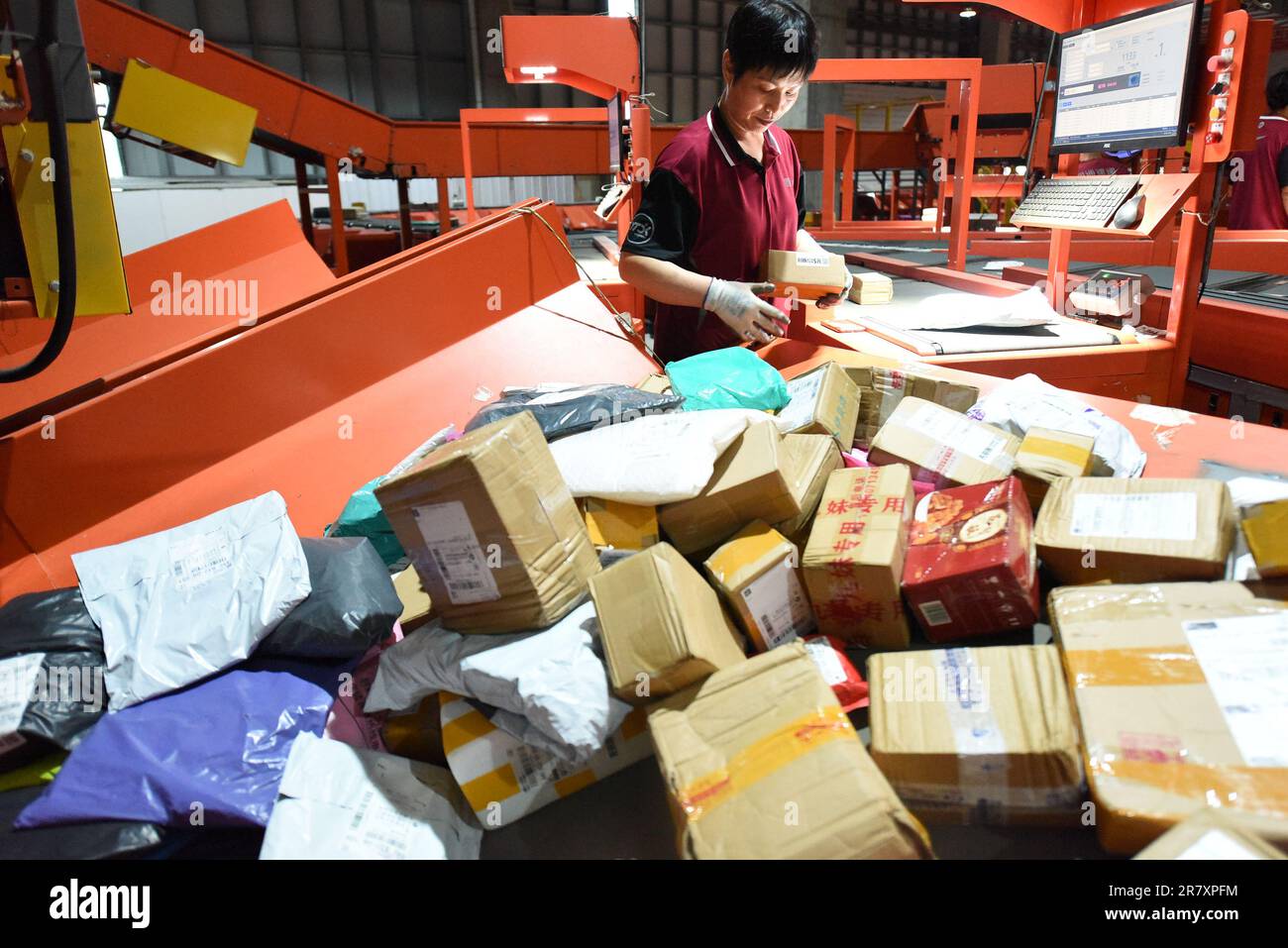Express workers sort parcels on an assembly line at an e-commerce ...