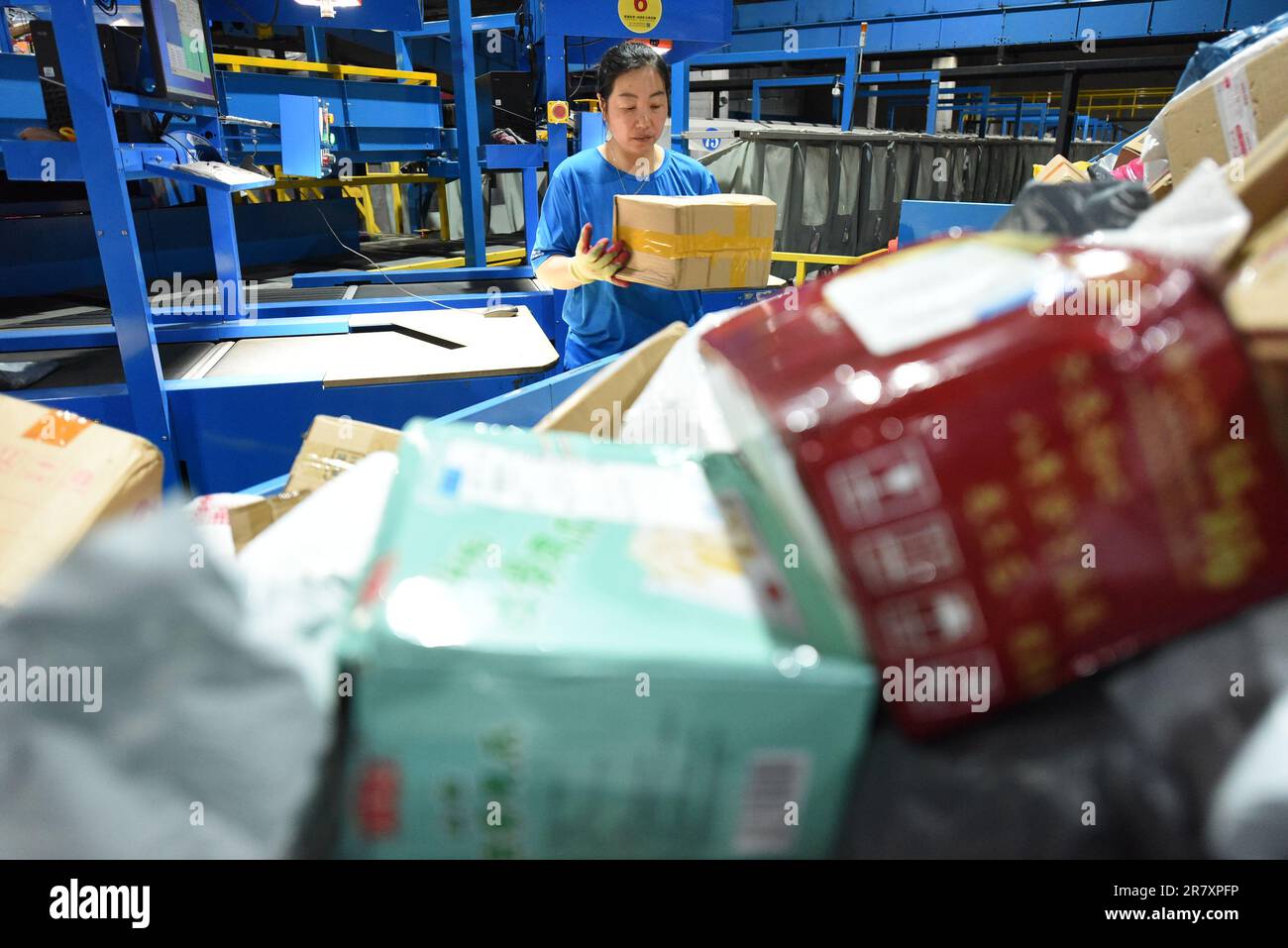 Express workers sort parcels on an assembly line at an e-commerce ...