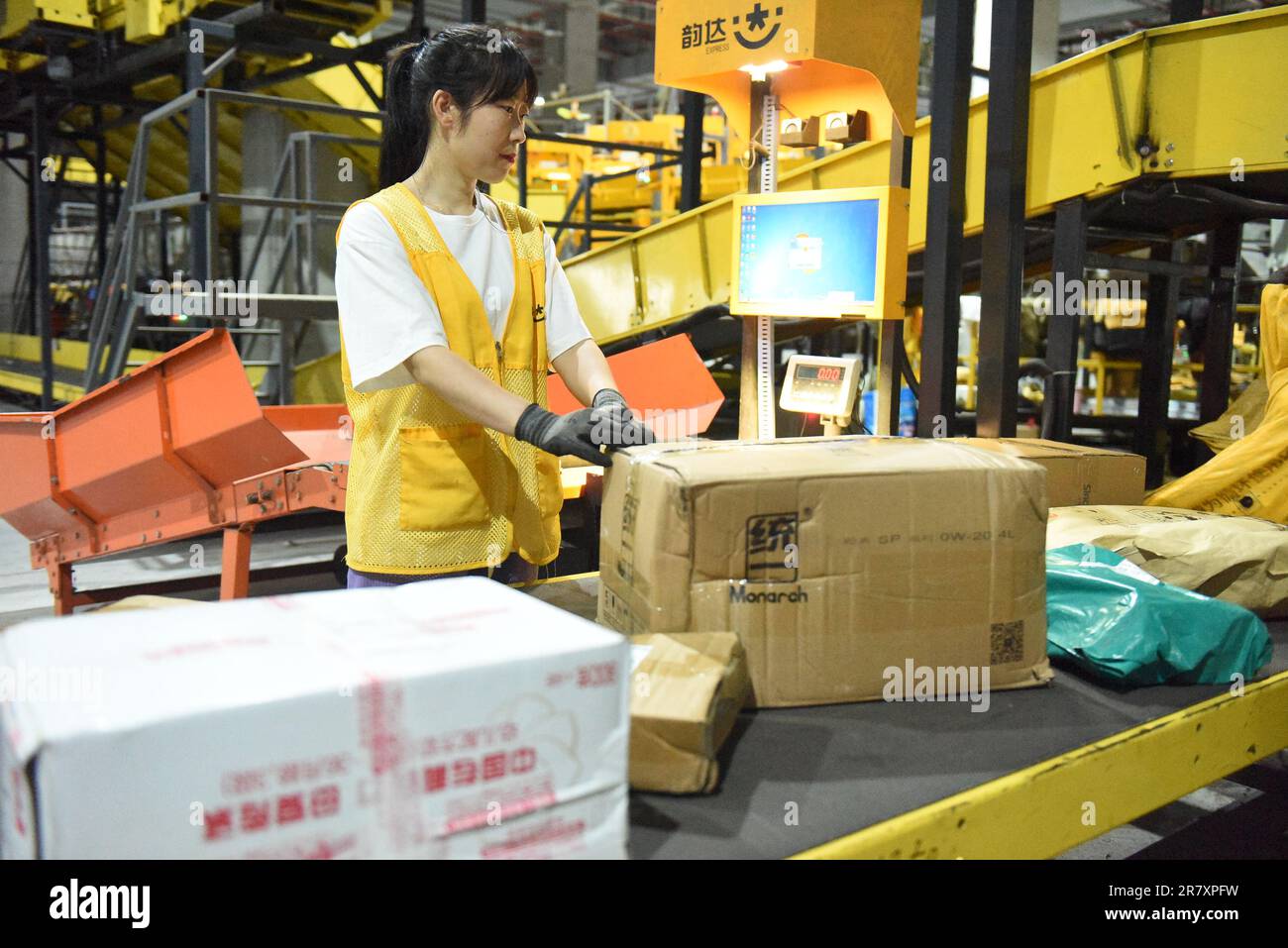 Express workers sort parcels on an assembly line at an e-commerce ...