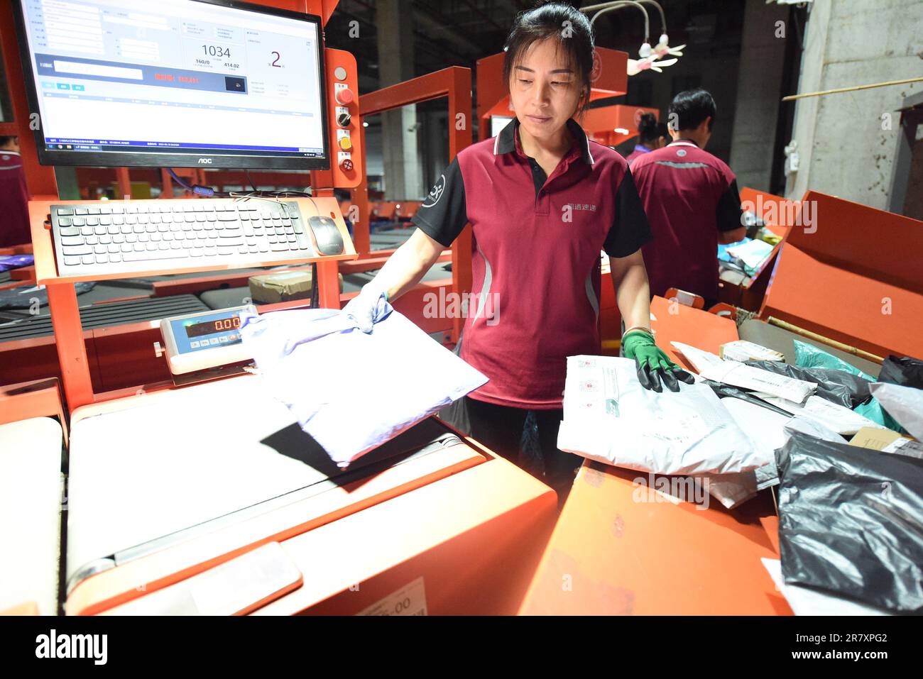 Express workers sort parcels on an assembly line at an e-commerce ...