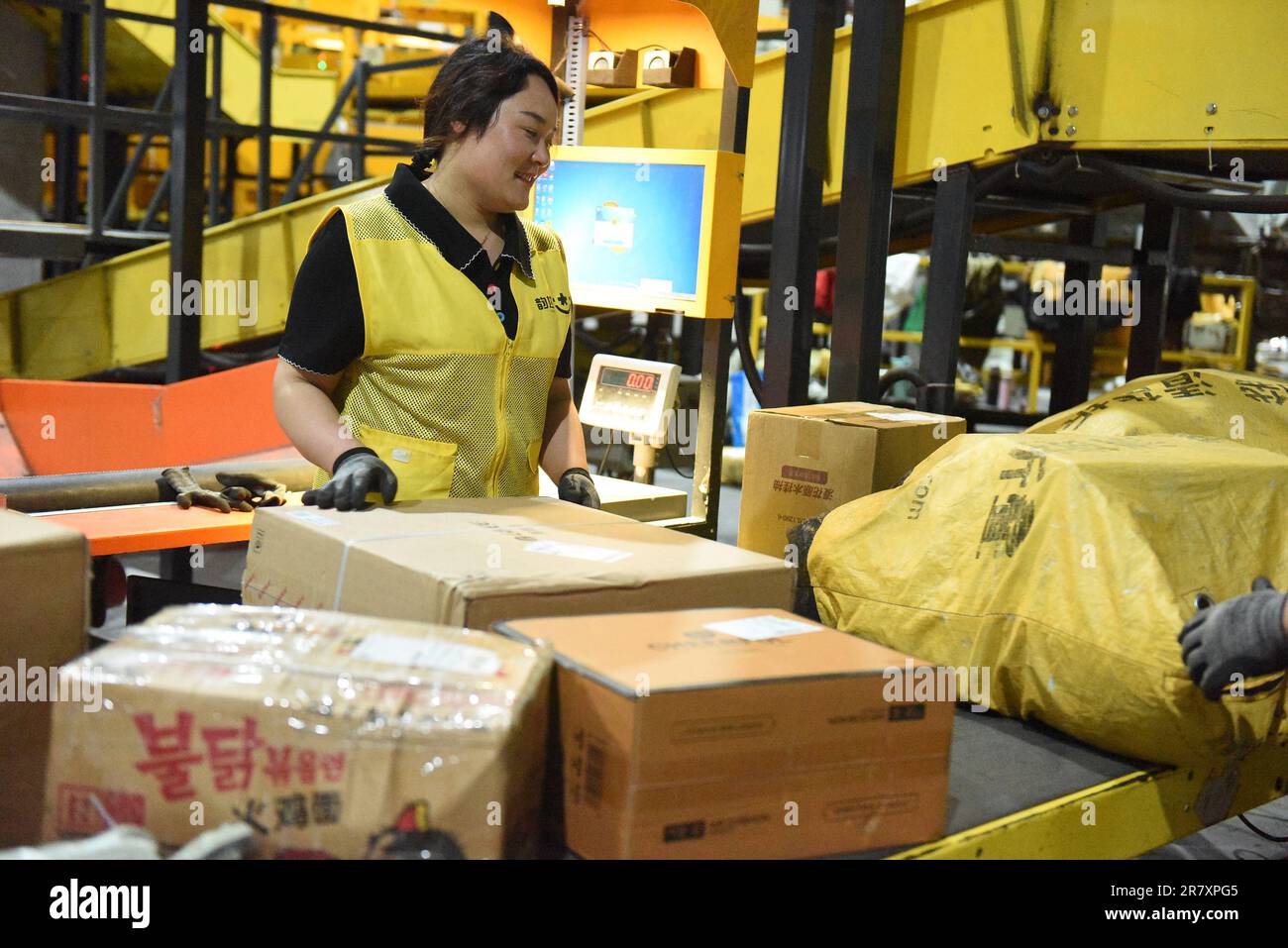 Express workers sort parcels on an assembly line at an e-commerce ...