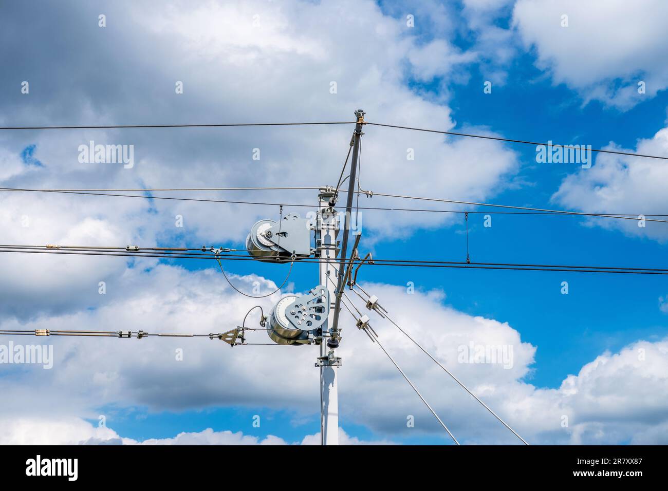 Traction poles of the railway line against the blue sky. Steel ...