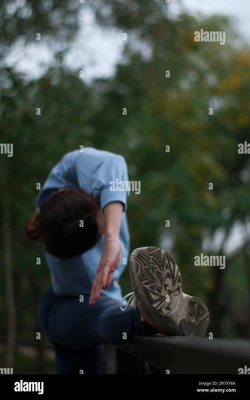 View of a girl with athletic body in blue gym suit is doing exercises ...