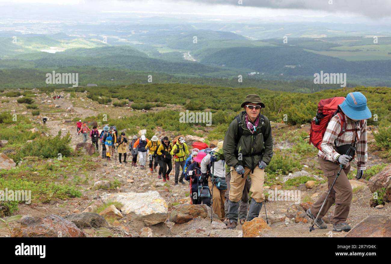 Climbers walk on Mt. Tokachi where the climbing season starts in Biei ...