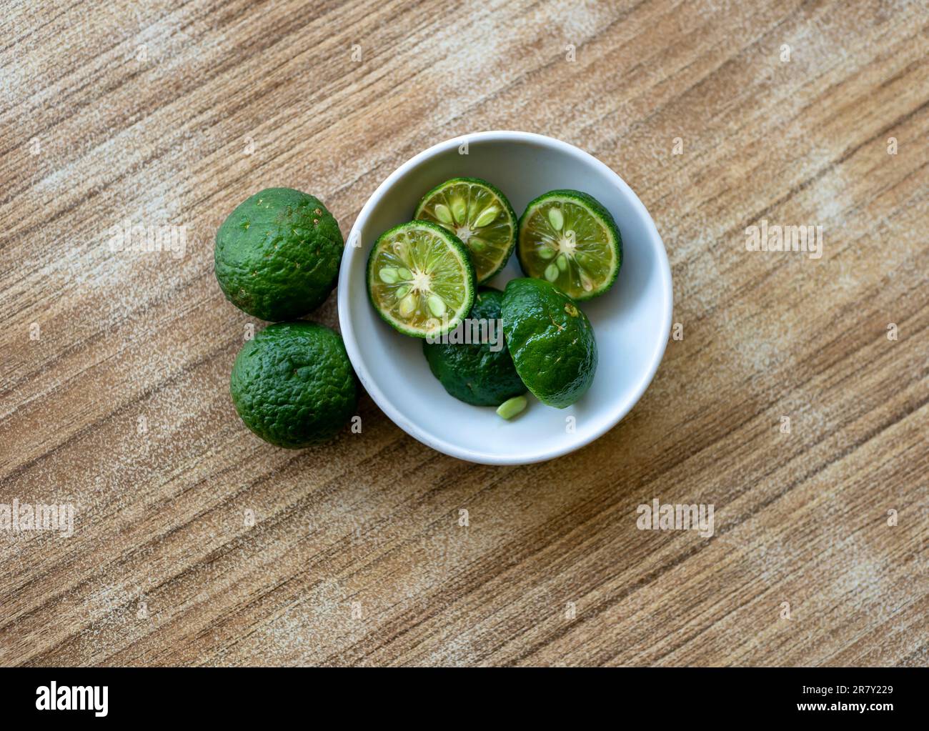 Top view of Citrus hystrix, called the kaffir lime, on the wooden table ...