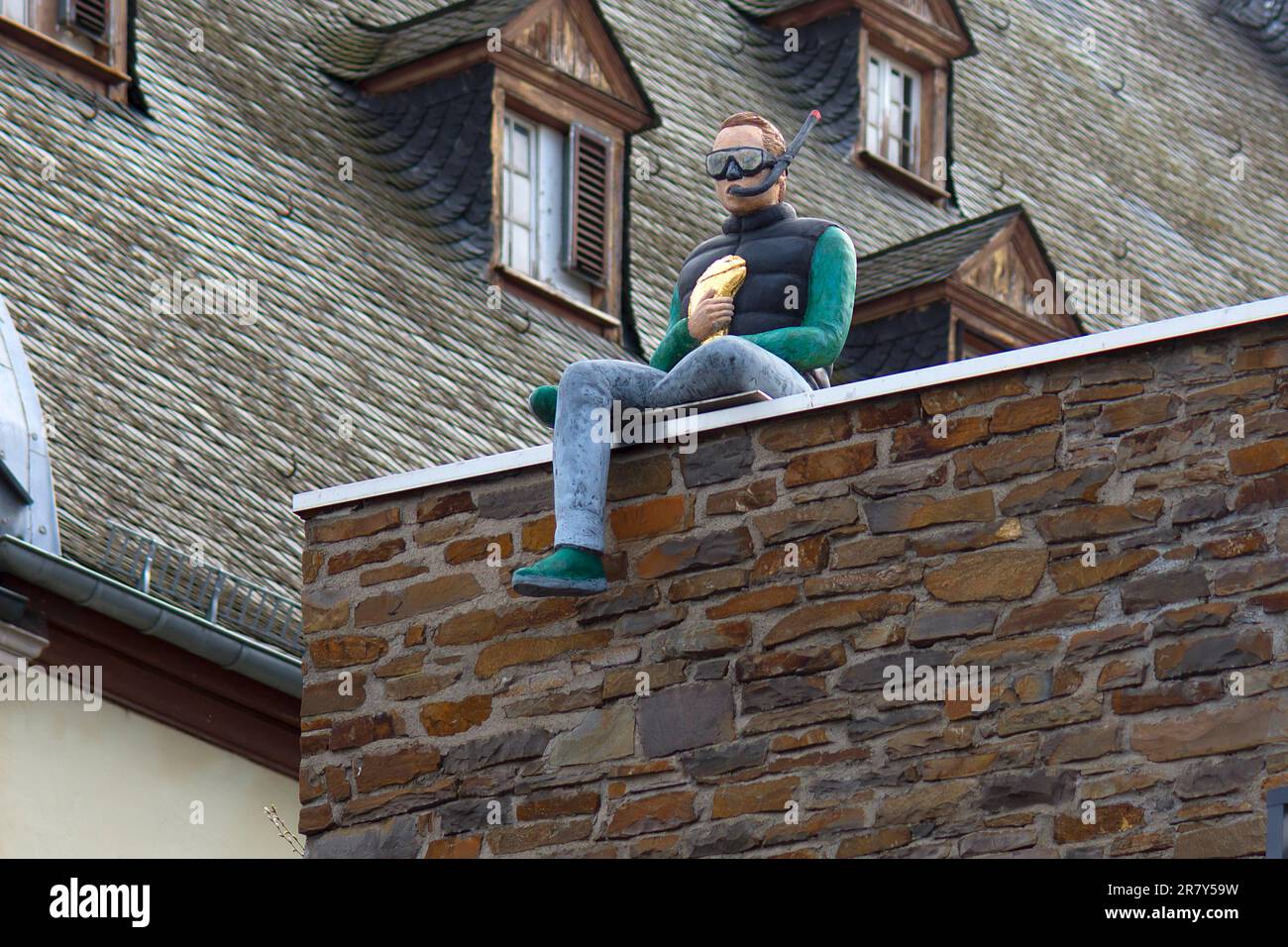 Male figure with diving goggles and snorkel sitting on a wall, Peter ...