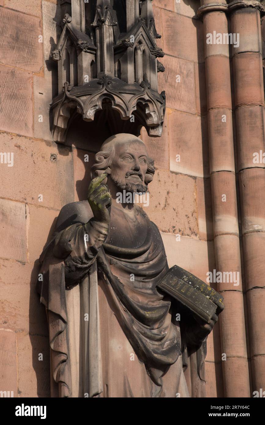 A closeup of intricately carved stone statue mounted above a brick wall ...
