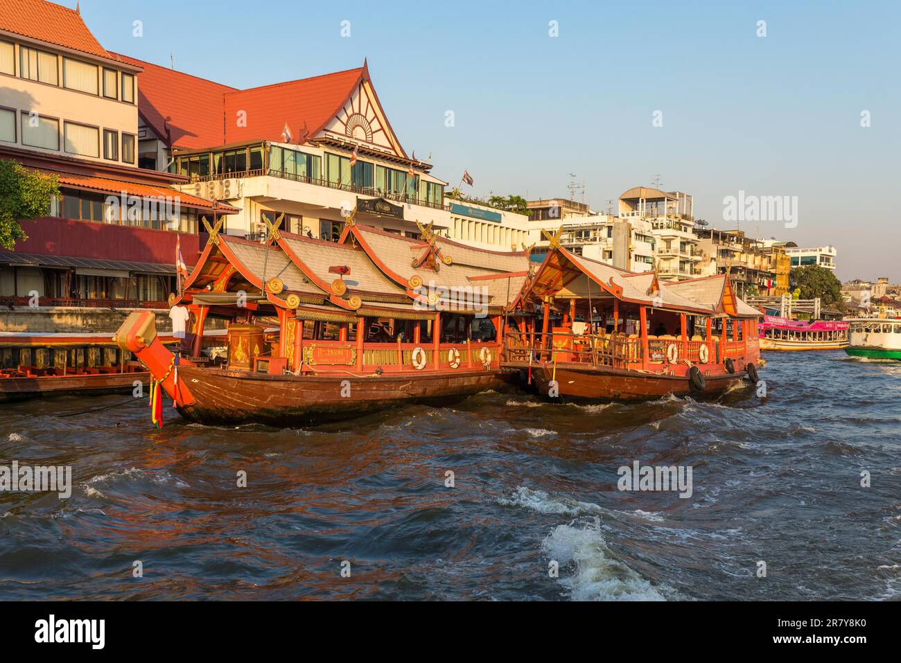 Ships at the pier for river cruise on a rice barge on the Chao Phraya ...