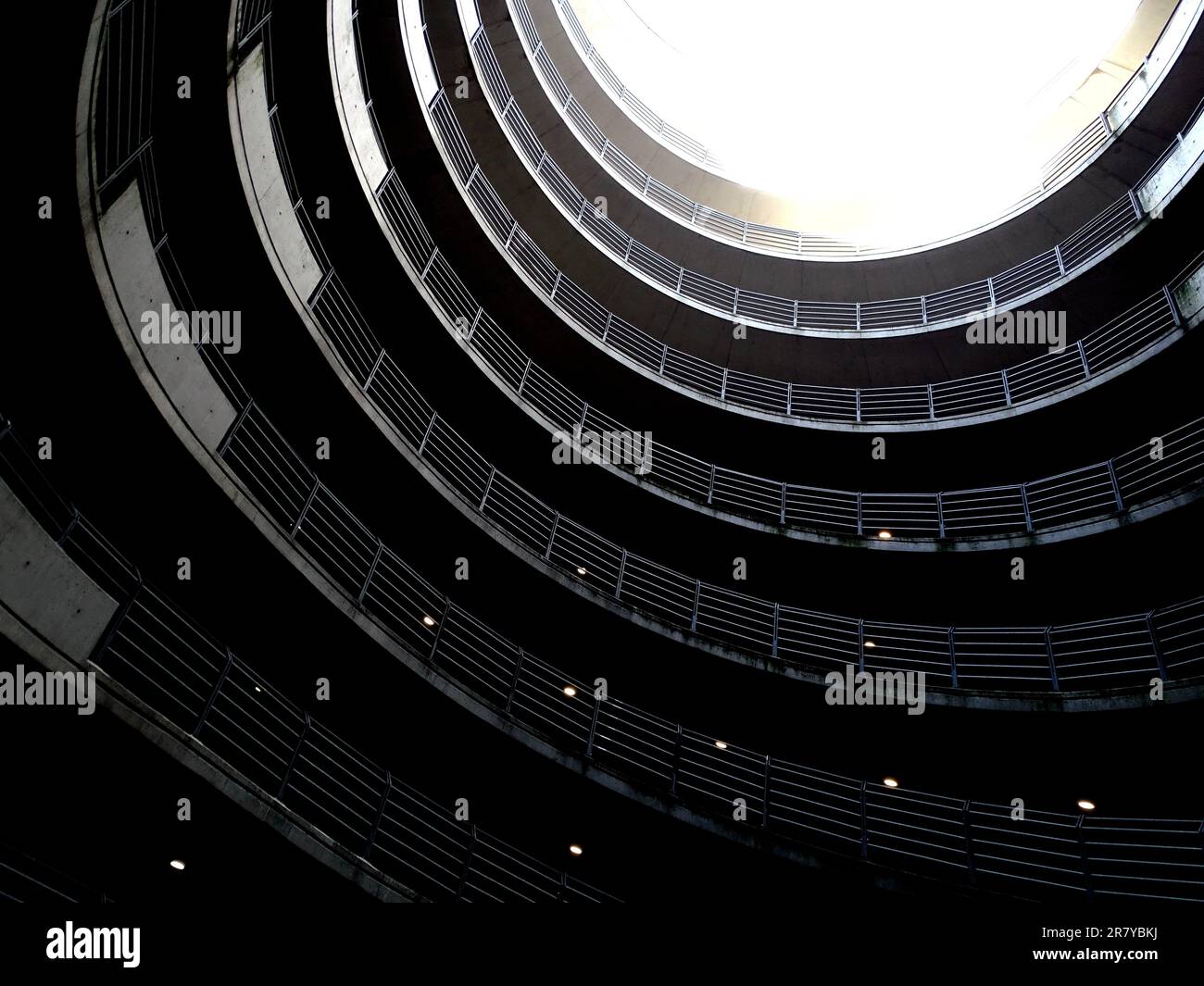 The interior view of a cylindrical round parking garage against the sky ...
