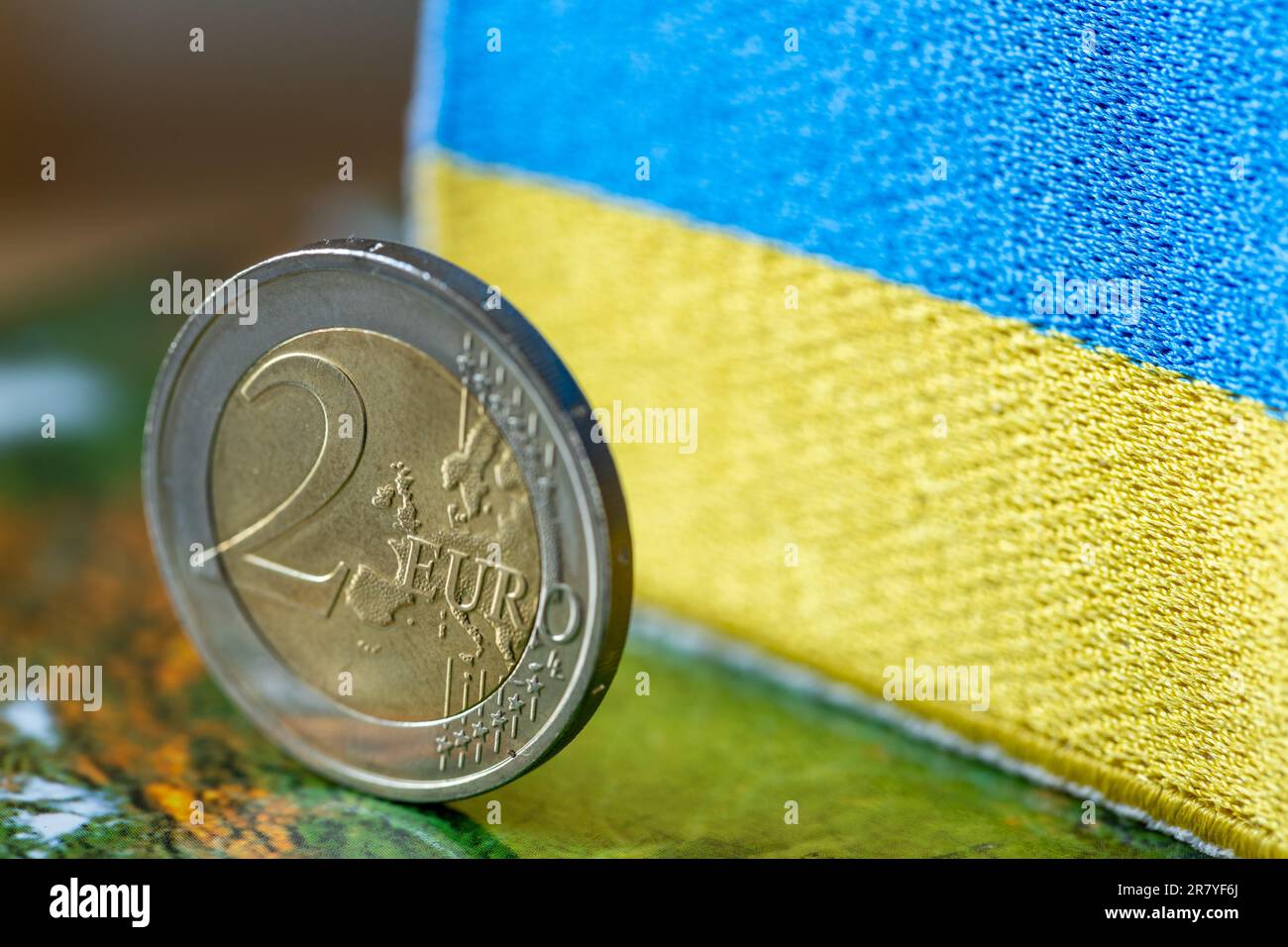 2 euro coin on the background of the Ukrainian flag concept, European ...