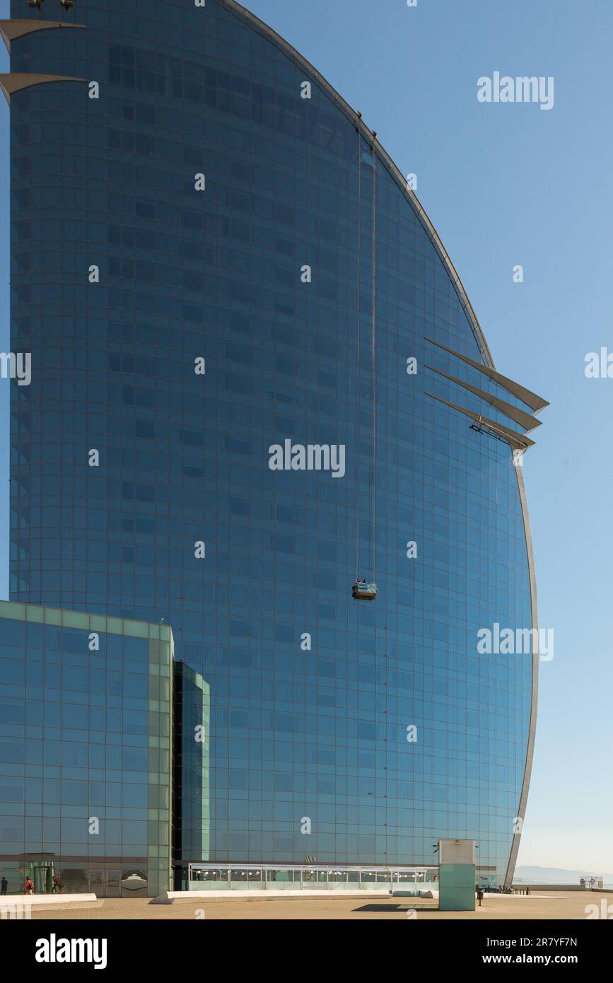 Worker or window cleaner on a swing stage at the W-Barcelona Hotel in Barceloneta. The building ...