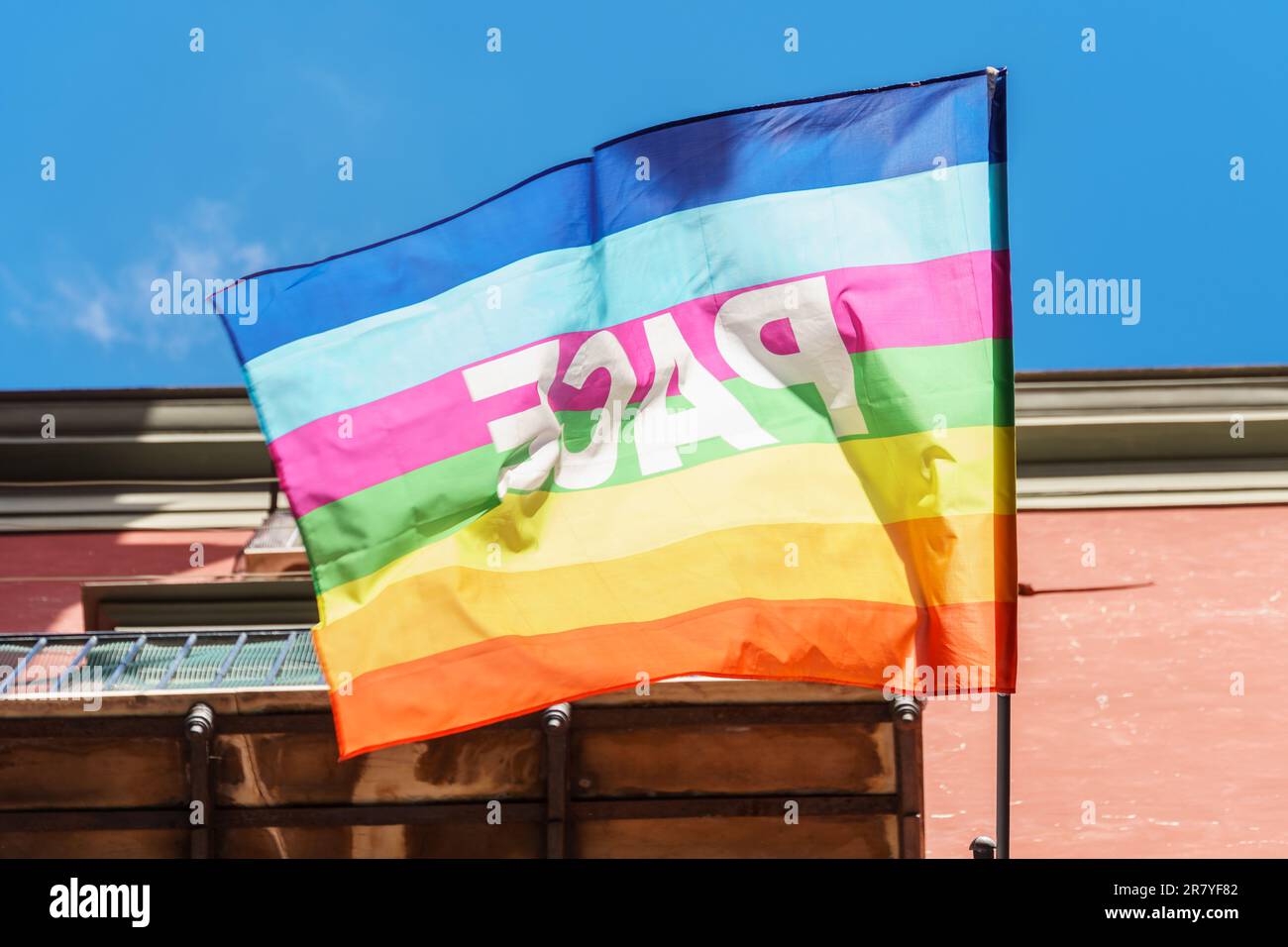 A colorful LGBT rainbow flag waving in the wind mounted on the side of ...
