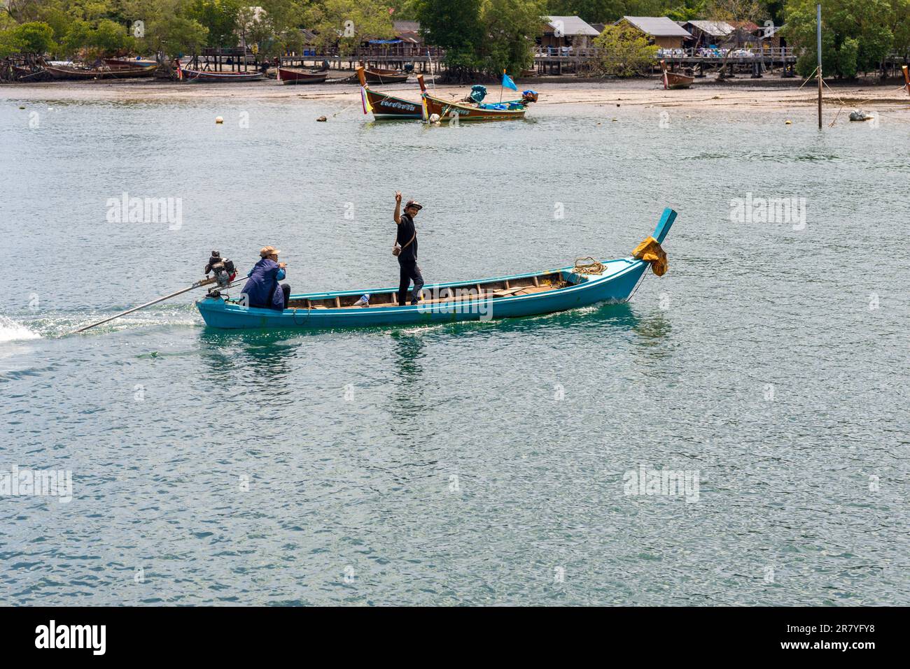 Couple reach the Saladan pier on a Thai boat with the typical outboard ...