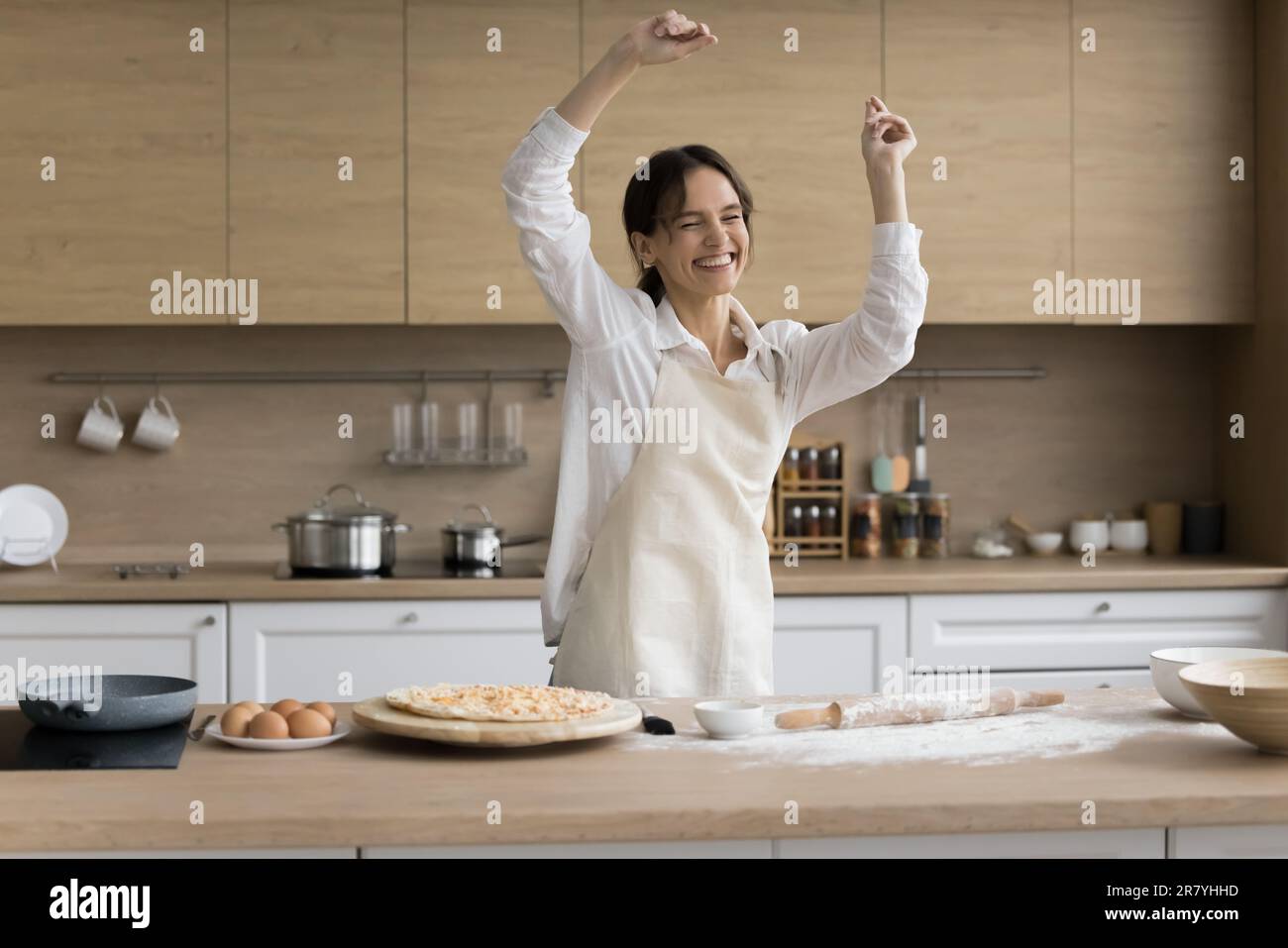 Happy woman dance in the kitchen while cooking homemade pizza Stock ...