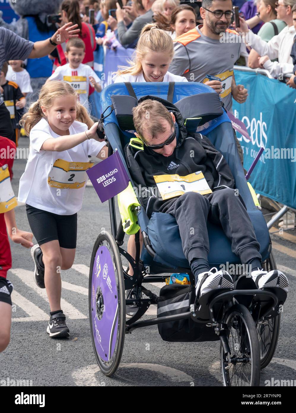 Rob Burrow is pushed by his daughters, Maya (left), 8, and Macy (right ...