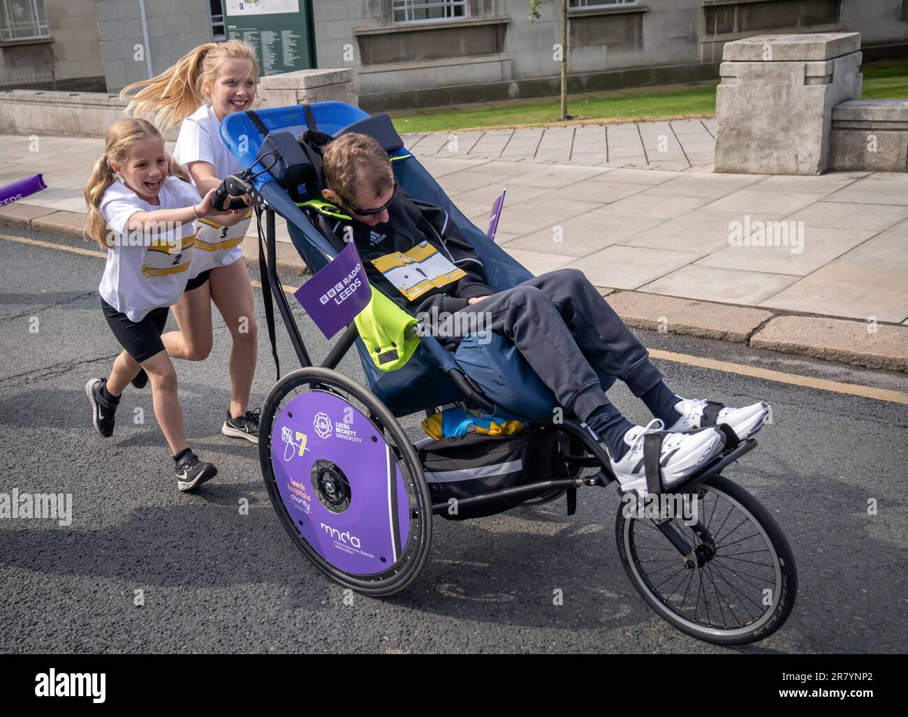 Rob Burrow is pushed by his daughters, Maya (left), 8, and Macy (right ...