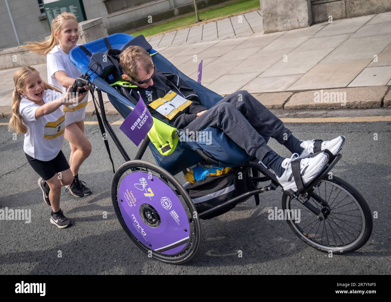 Rob Burrow is pushed by his daughters, Maya (left), 8, and Macy (right ...