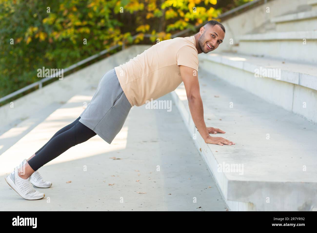 Successful hispanic sportsman doing various physical exercises, morning ...