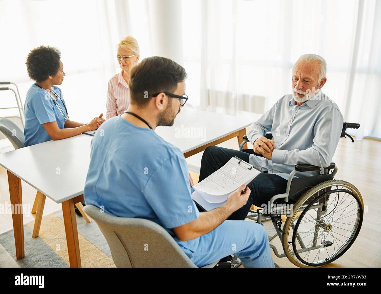 Doctor or nurse caregiver helping senior people in a wheelchair and a ...