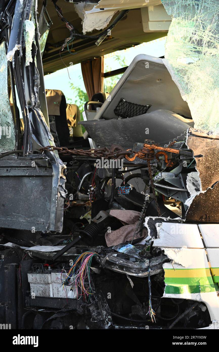 A front part of the bus is heavily damaged after a head-on crash with a ...