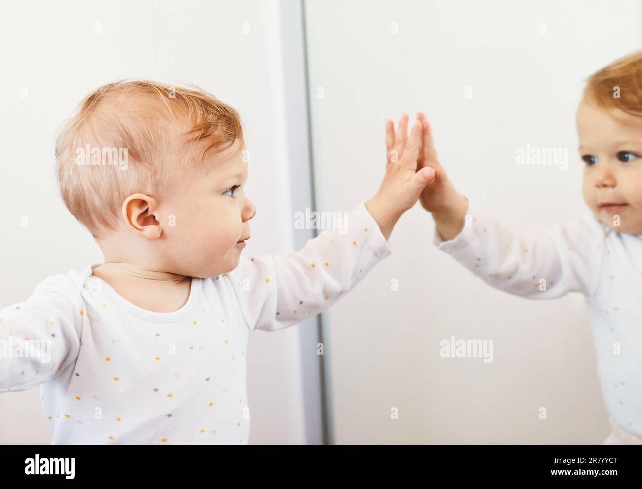 Little baby bor playing and looking at mirror at home Stock Photo - Alamy