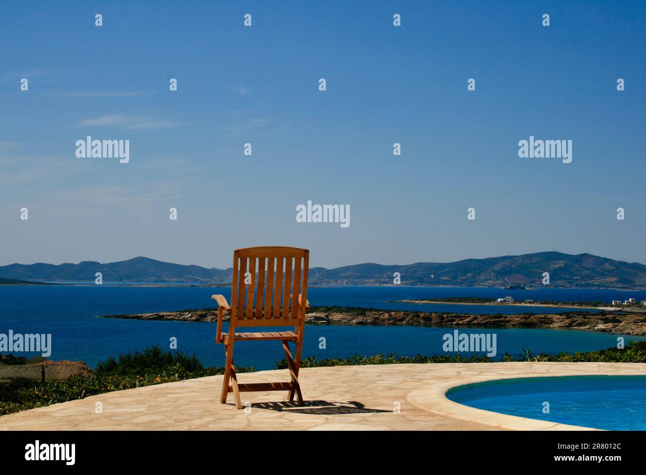 Wooder chair by the pool with view to the Aegean Sea Stock Photo - Alamy