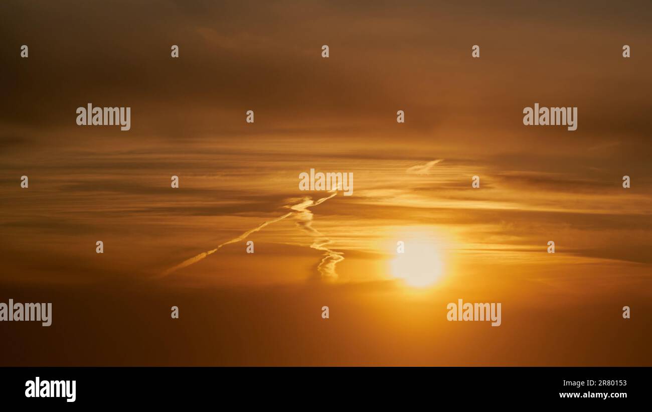 As the sun began to dip below the horizon, the clouds turned shades of ...