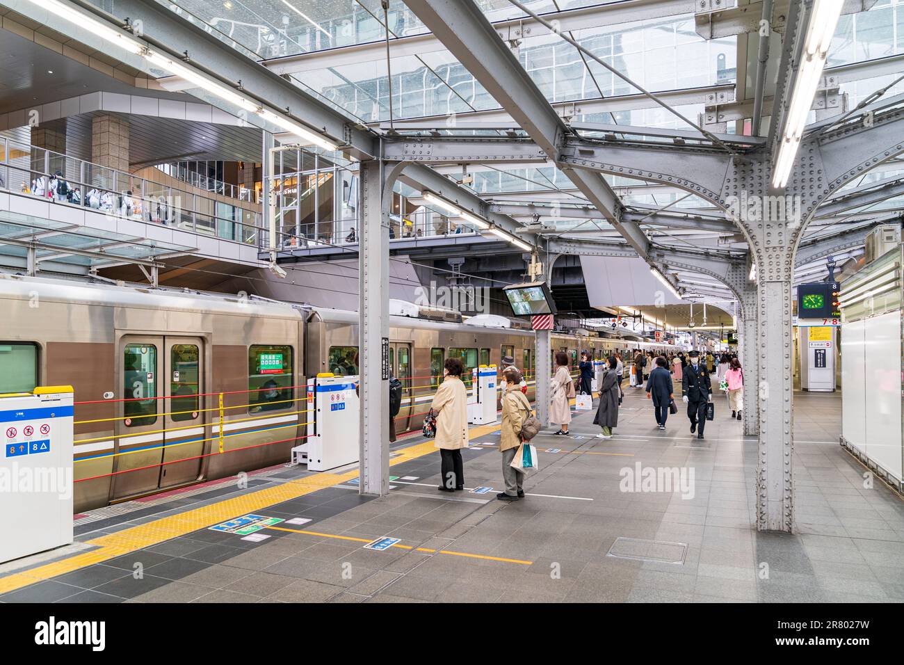 Japanese commuters waiting on designated platform lines for the next ...