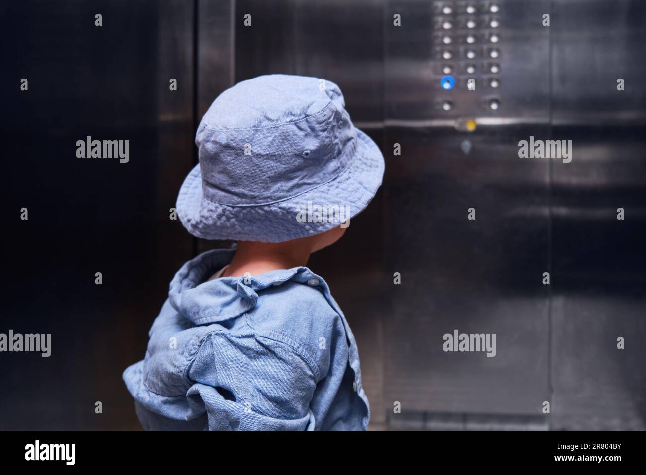 Happy baby rides in the elevator of an apartment building with buttons ...