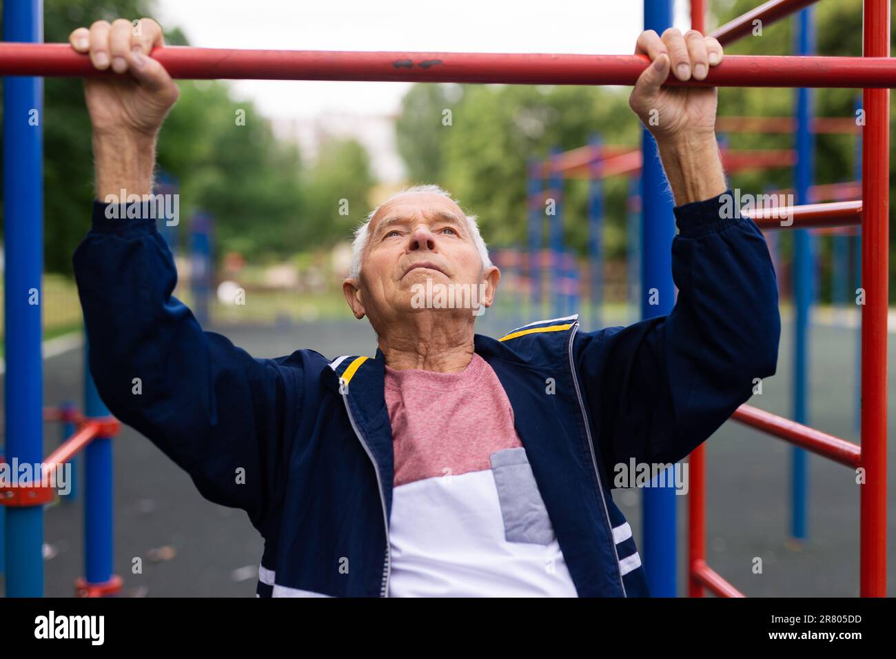 Active grandpa pulls up on horizontal bar on sports ground Stock Photo ...