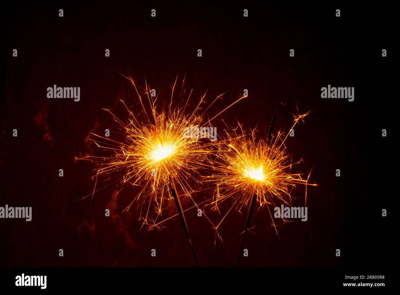 Bright burning sparklers on the dark background Stock Photo - Alamy