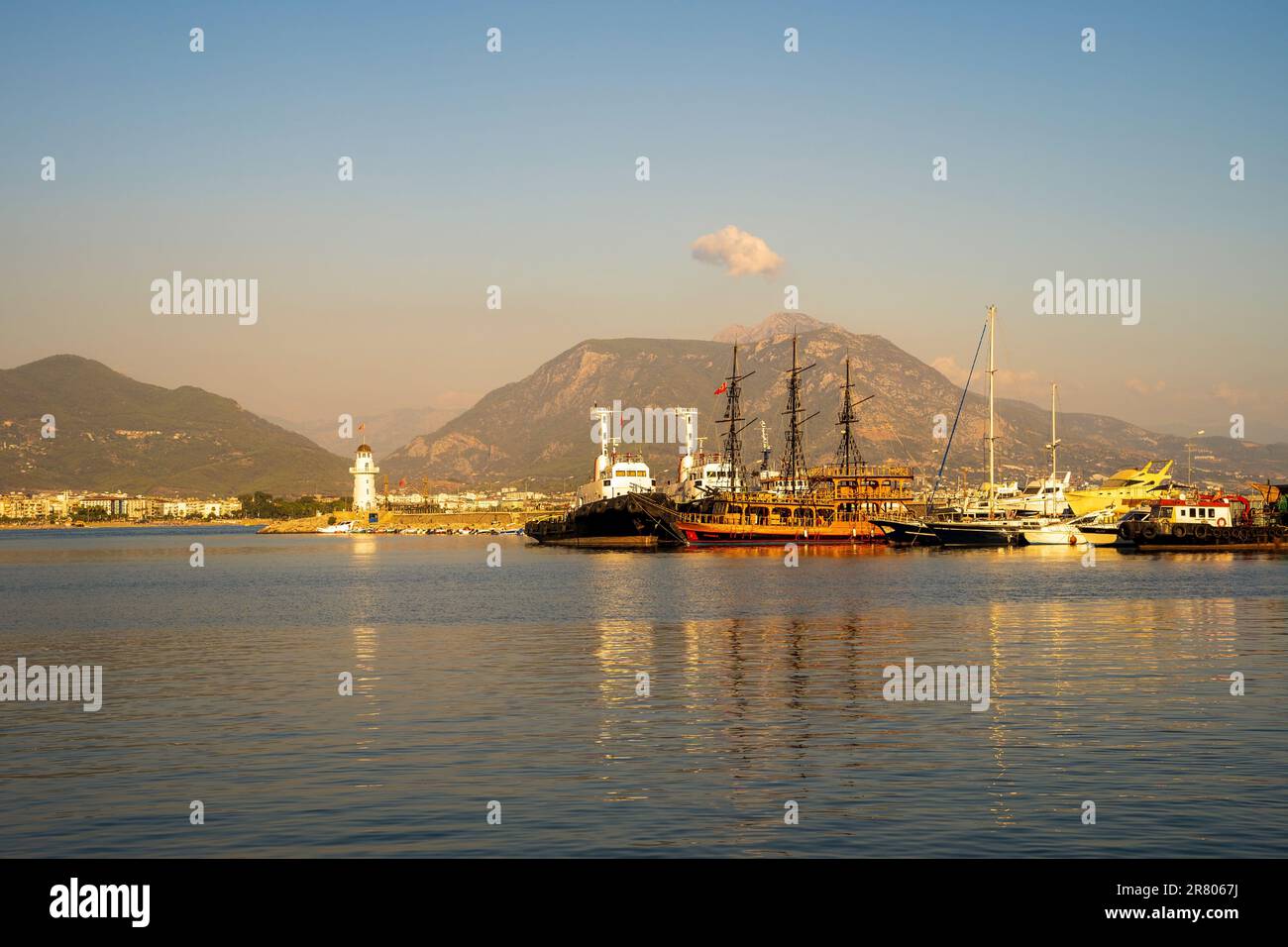 Pirate sailing pleasure cruise ship in the bay with a lighthouse in the ...