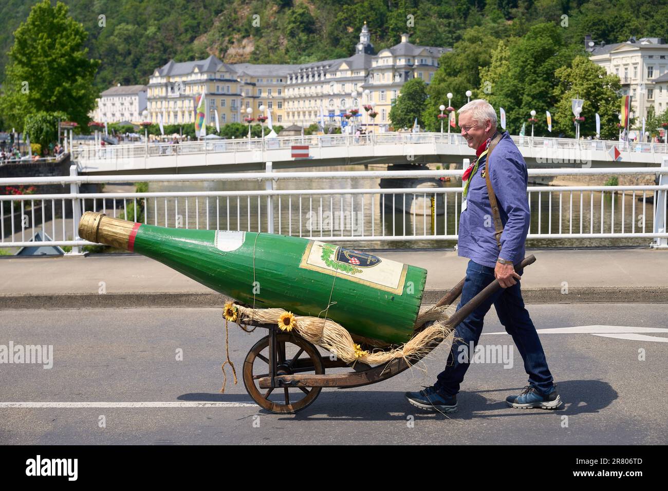 Bad Ems, Germany. 18th June, 2023. A vintner from Enkirch pushes an oversized wine bottle in ...