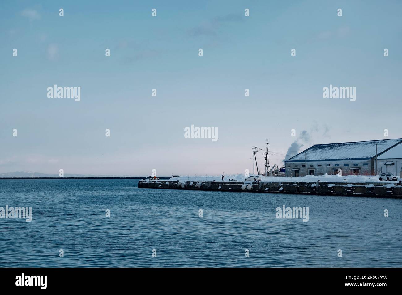 An idyllic winter scene featuring a boat dock next to a warehouse in ...