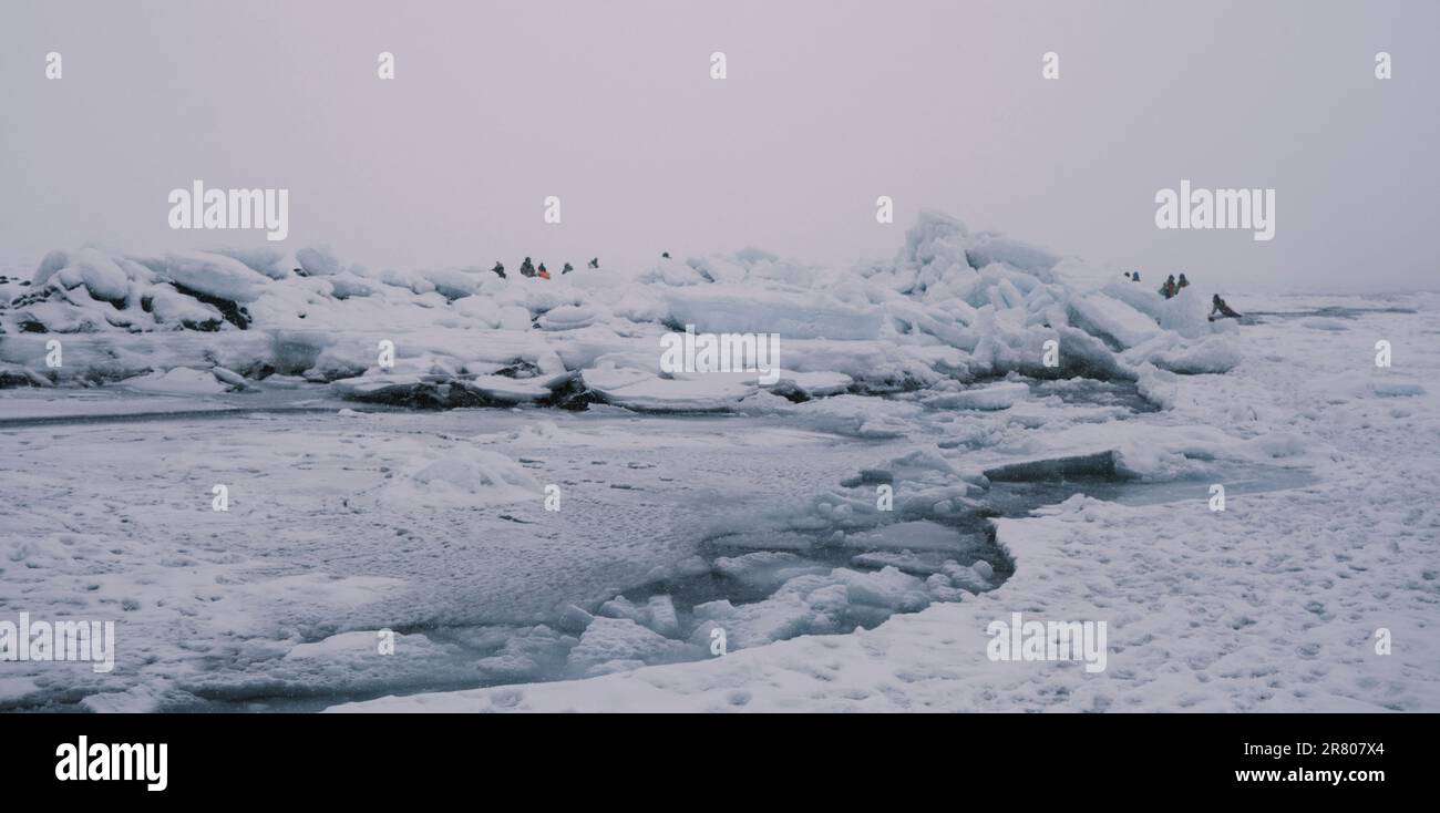 A serene winter landscape with large frozen ice blocks resting on a ...